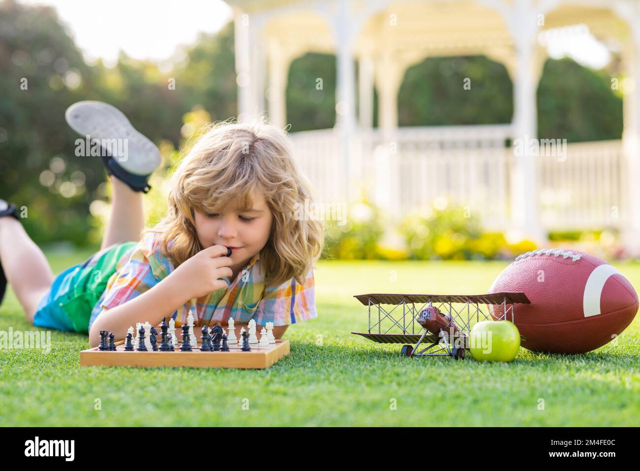 Summer games and outdoor activities for kids. Child playing chess game ...
