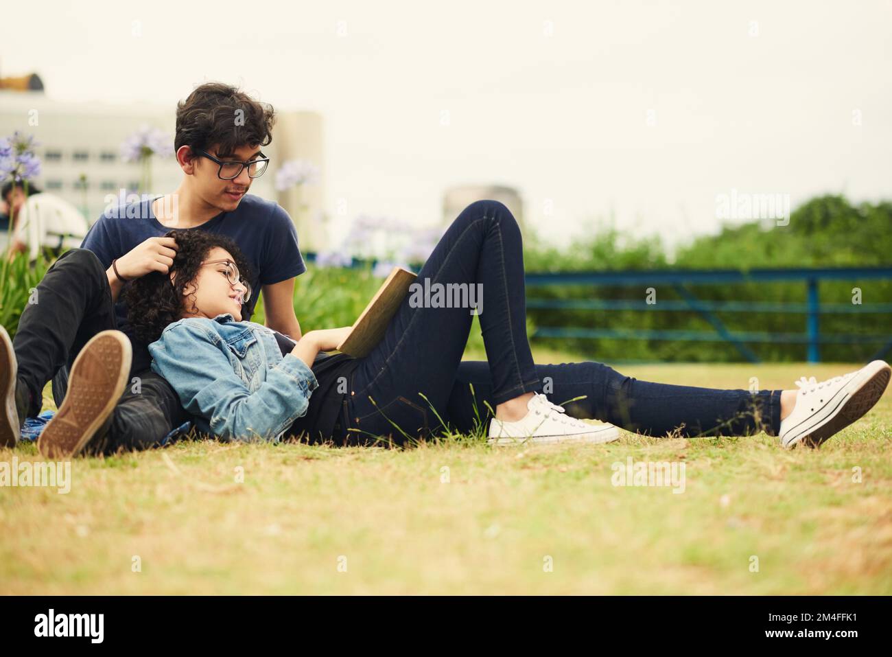 This is a great way to spend time together. a teenage couple reading a ...