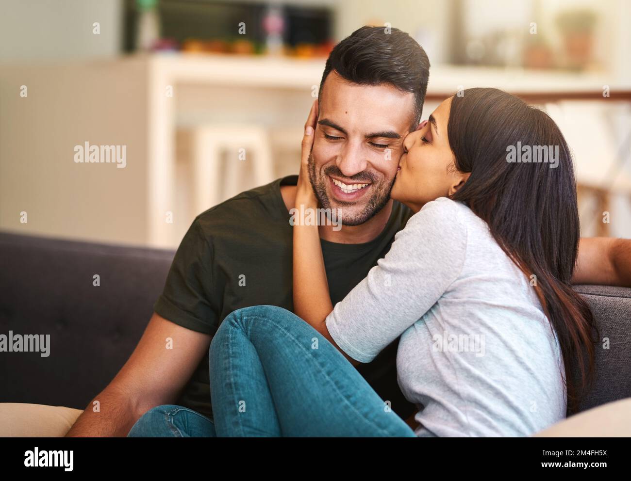 Kisses for my favourite person. an affectionate young couple relaxing ...