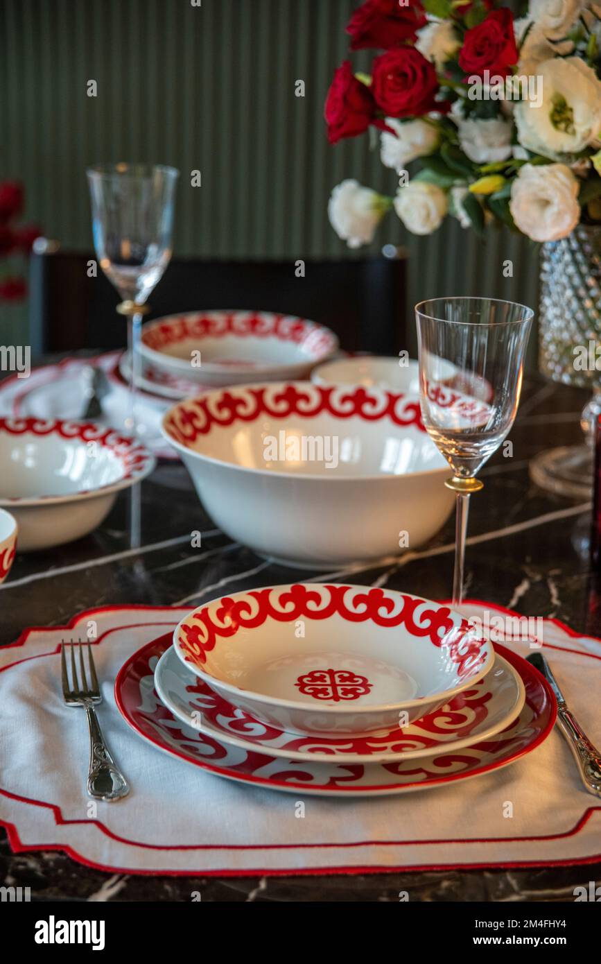 luxury designed dinner table with red and white plates Stock Photo - Alamy