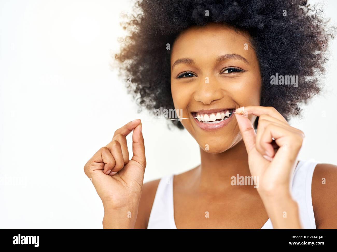 How I get my teeth completely clean. an attractive young woman flossing ...