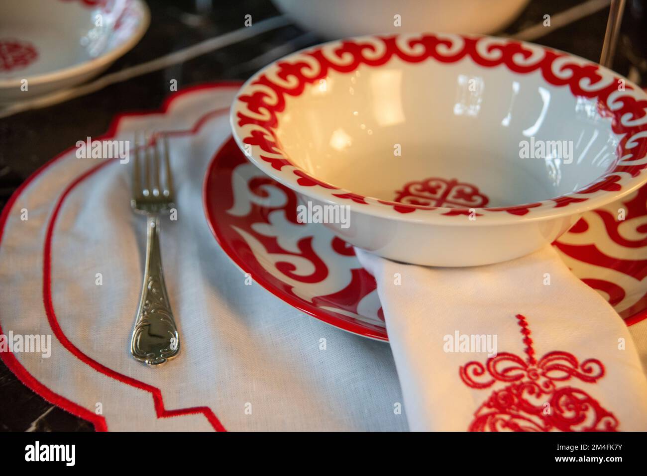 luxury designed dinner table with red and white plates Stock Photo - Alamy