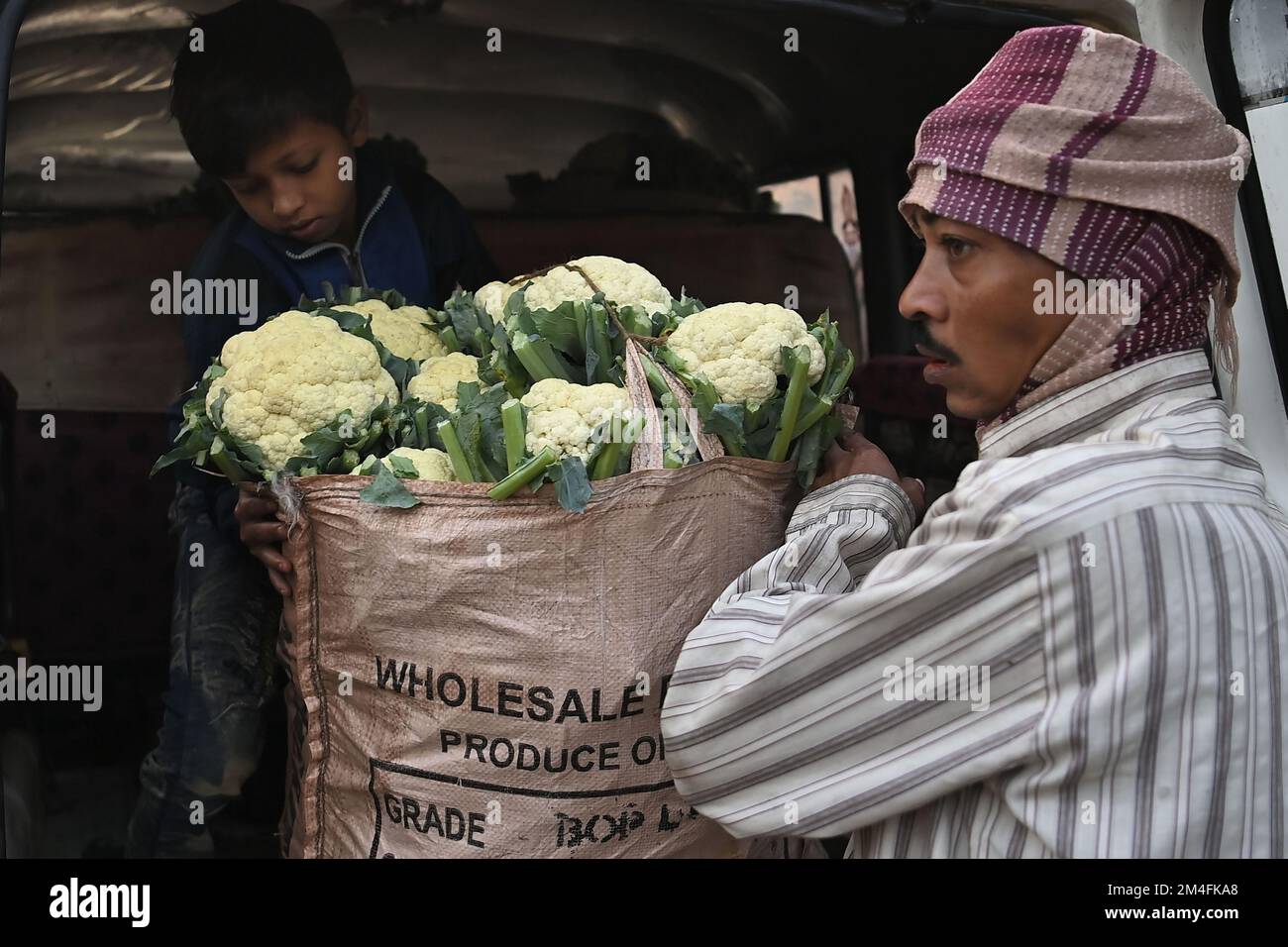 Farmers brining vegetables to a wholesale vegetable market, at Sonamura ...