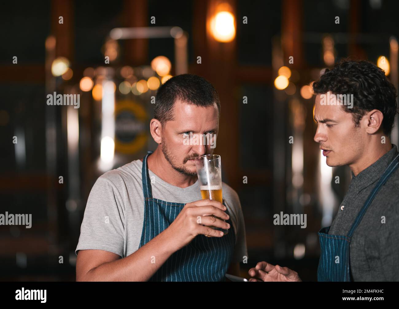 How is this one tasting. two working businessmen tasting beer inside of ...