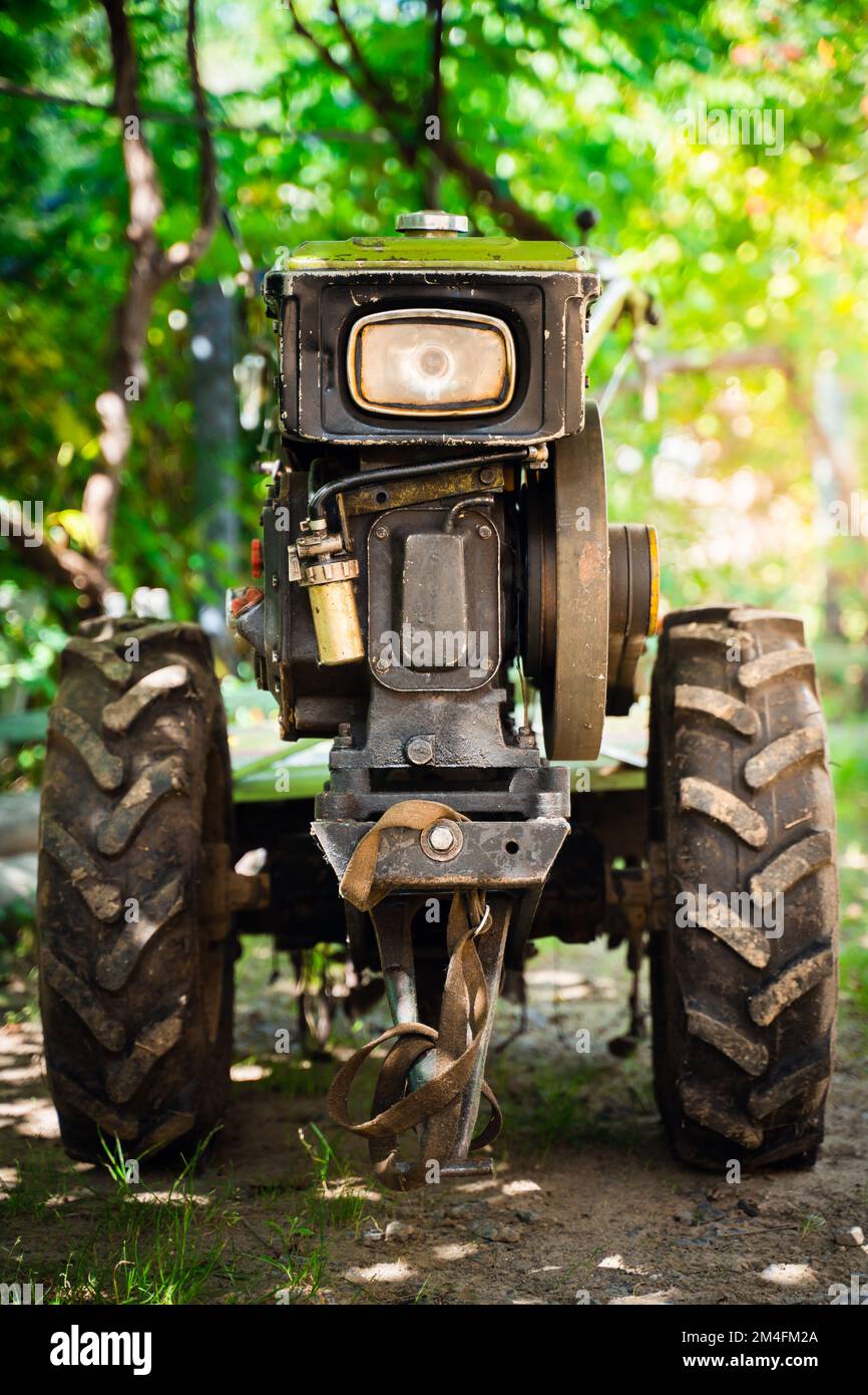 Old walk-behind tractor for tillage in agriculture close-up on a framed ...