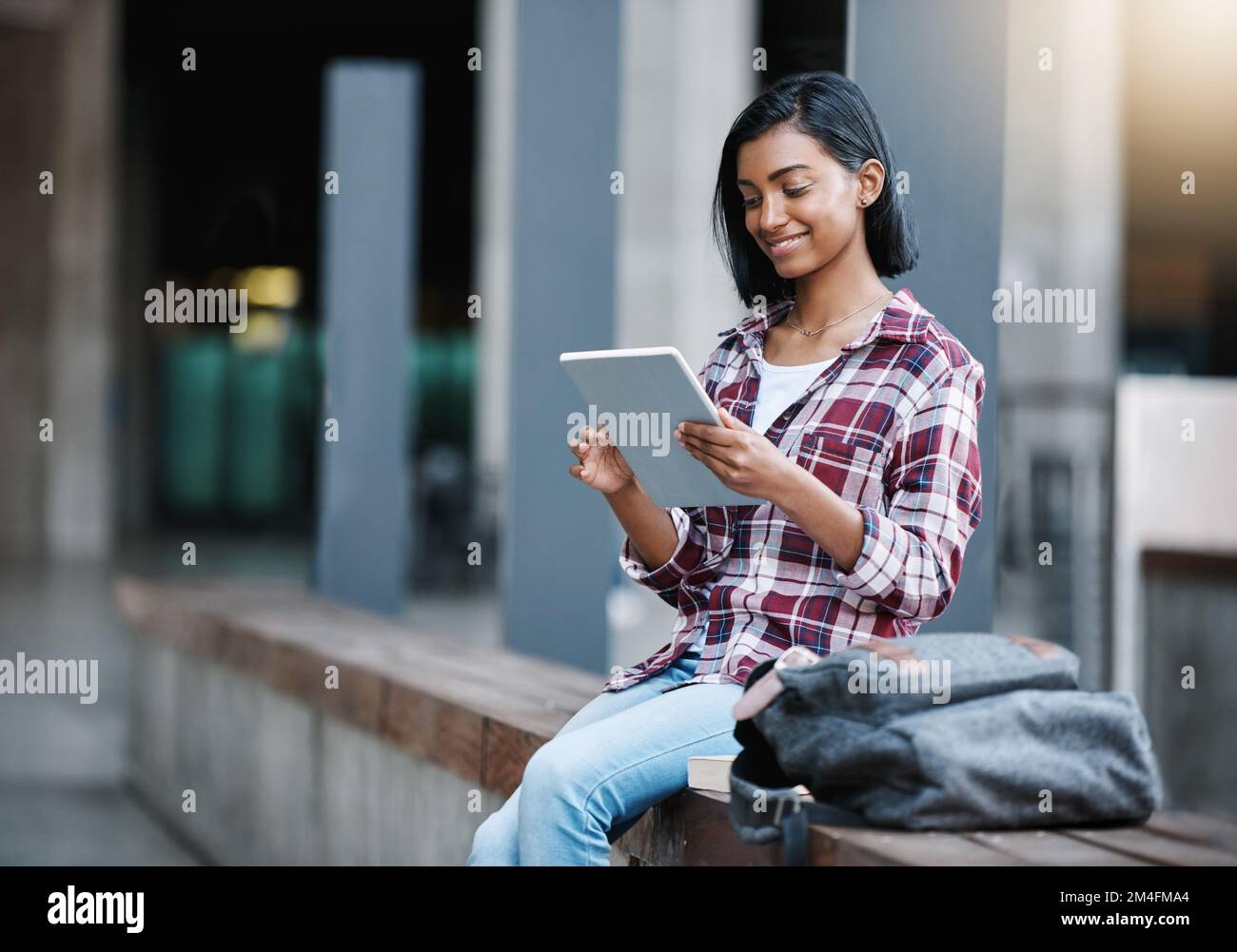 Making the most of the campus wifi. an attractive young female student ...