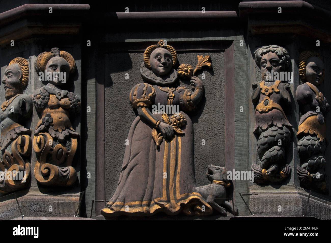 Gilded Renaissance lady with dog at her feet between male and female ...