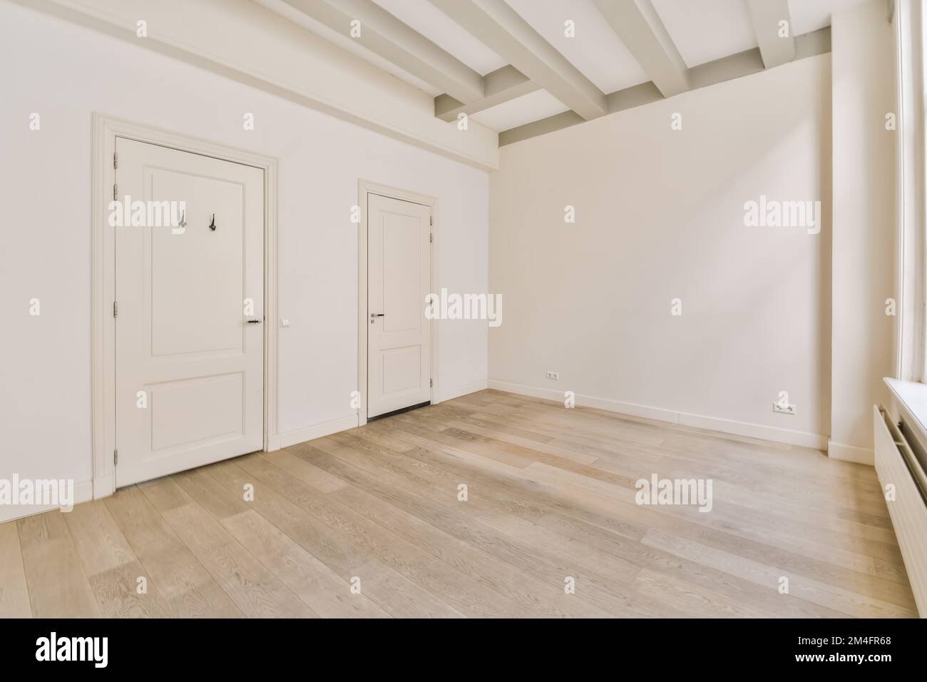 an empty room with white walls and wood flooring in the center of the ...
