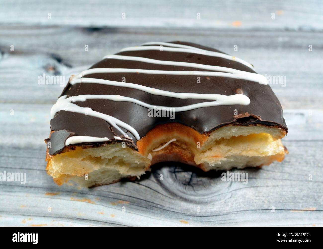 Brown chocolate ring donut with white chocolate sauce, A glazed, yeast raised, American style ...