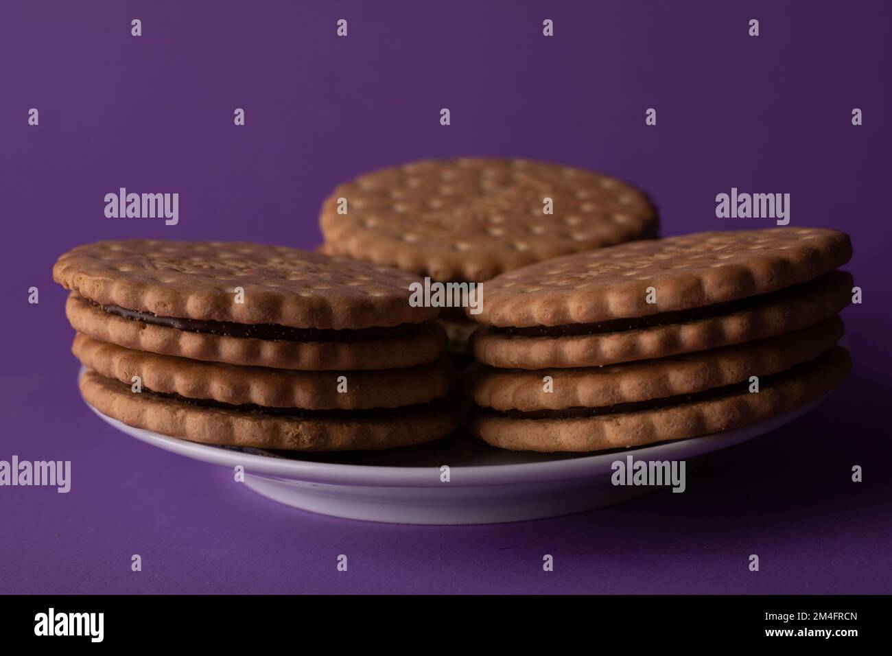 photo round cookies with a layer of chocolate lies stacked on a white ...