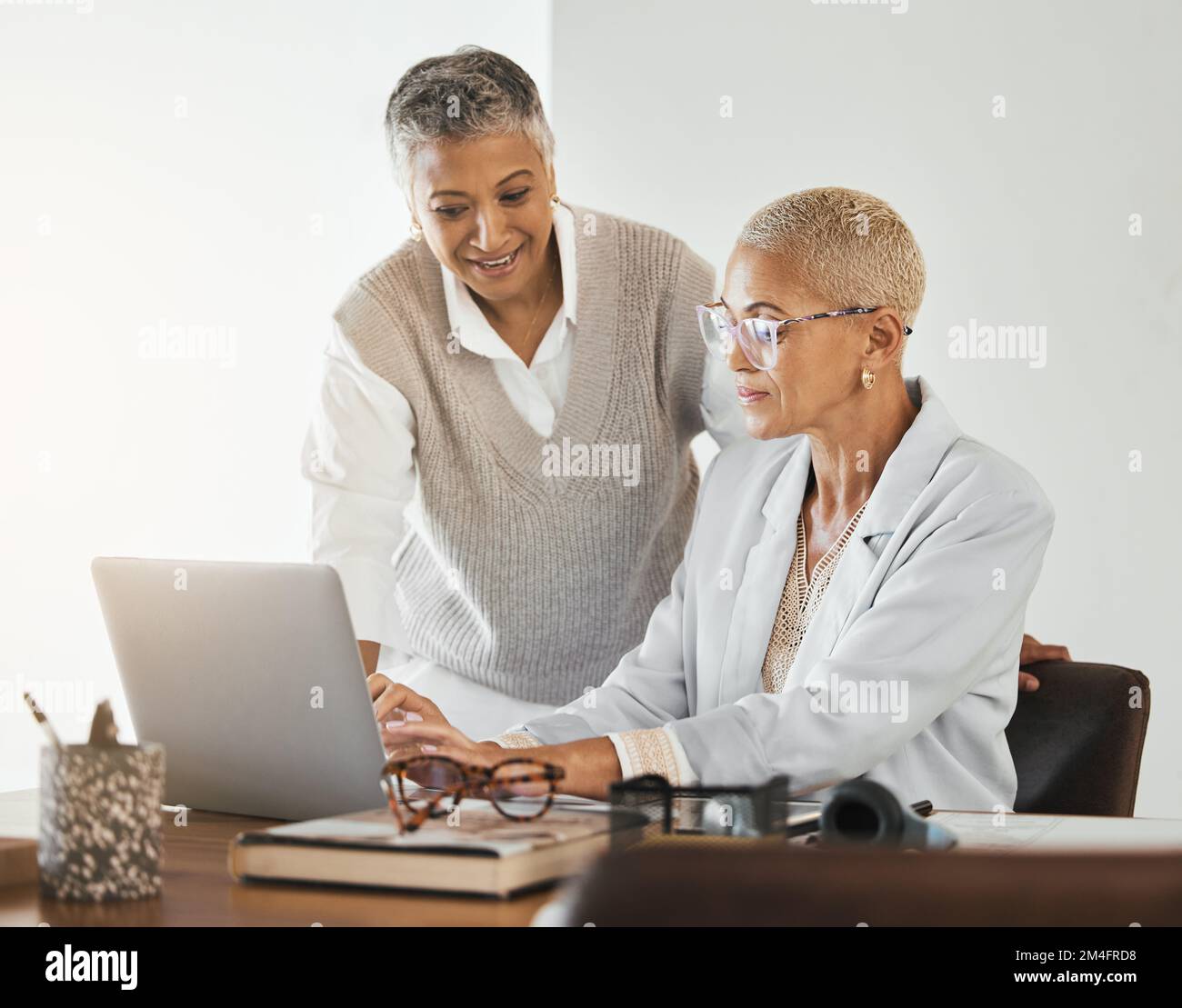 Laptop, office and senior business women in collaboration planning a ...