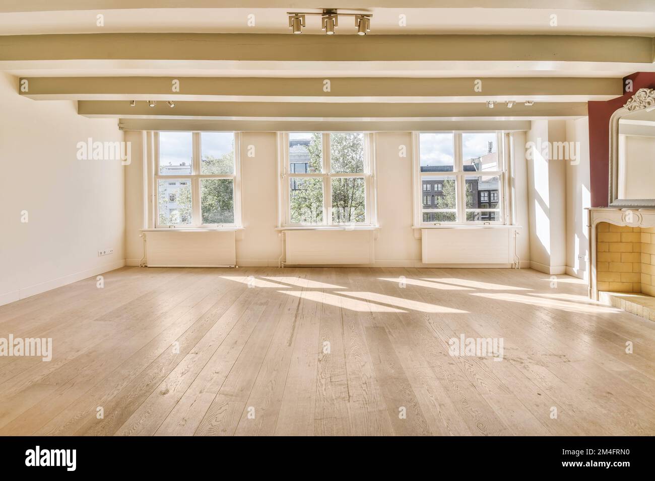 an empty living room with wood flooring and large windows in the room ...