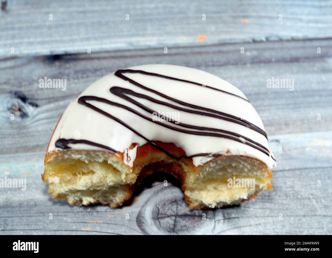 White chocolate ring donut with brown chocolate sauce, A glazed, yeast raised, American style ...