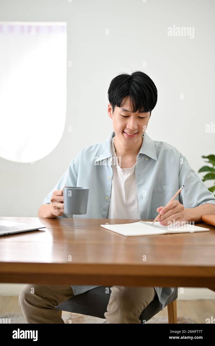 Portrait, Handsome young Asian male college student sipping coffee ...