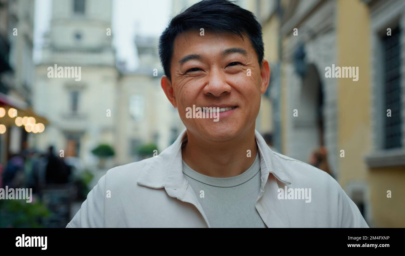Positive friendly man looking at camera smiling satisfied male tourist ...