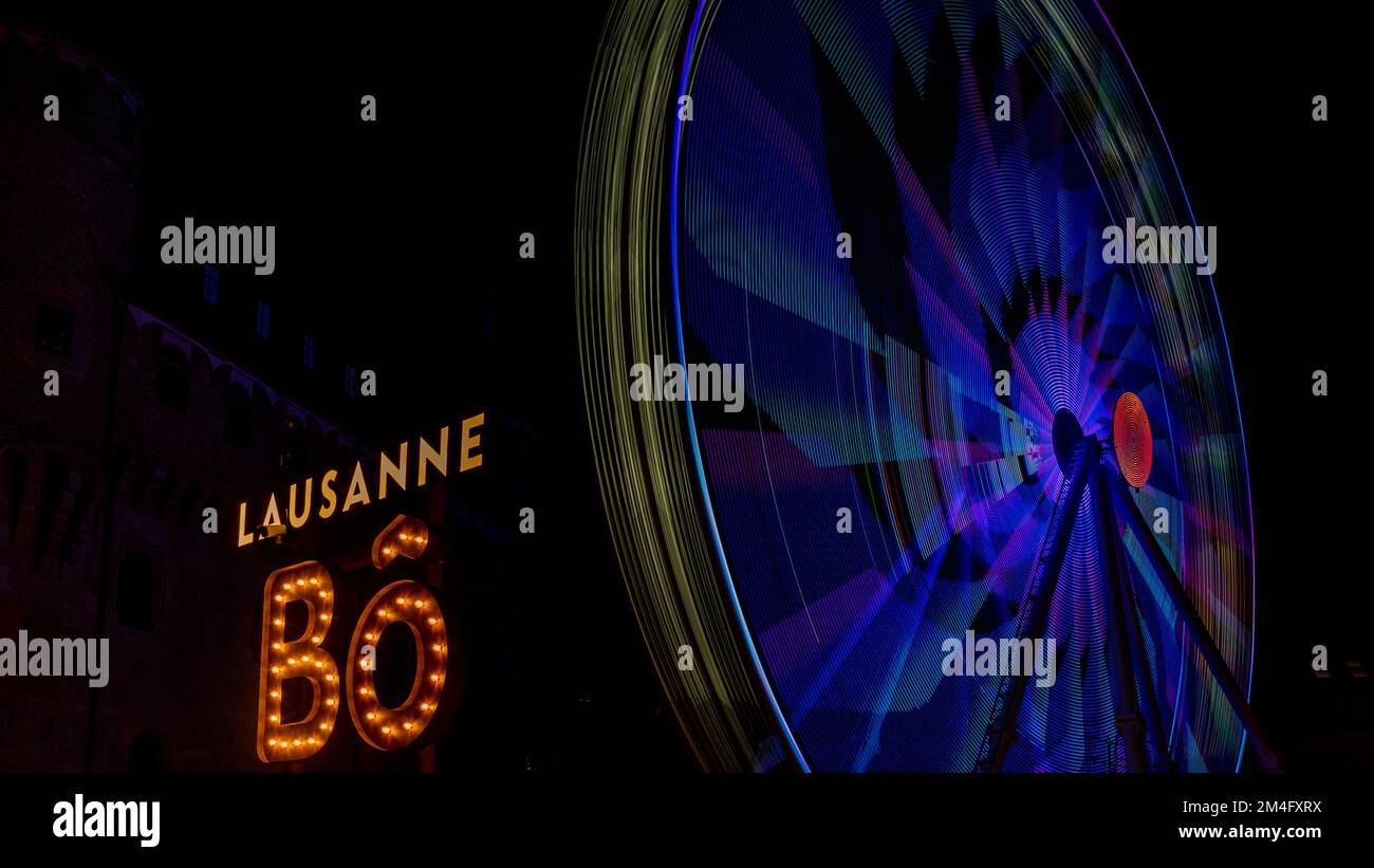 Ferries wheel rotating at night with lights at amusement park. Bo light ...