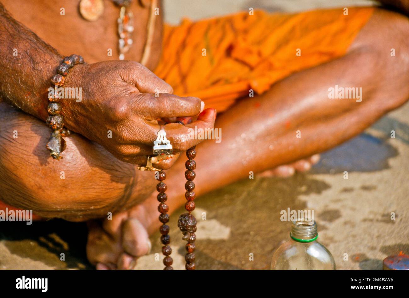 Sadhu, holy man, doing his washing and praying ceremony in the morning ...