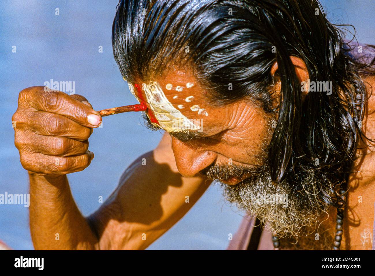 Rama-Sadhu applying his tilak as part of the morning pooja Stock Photo ...