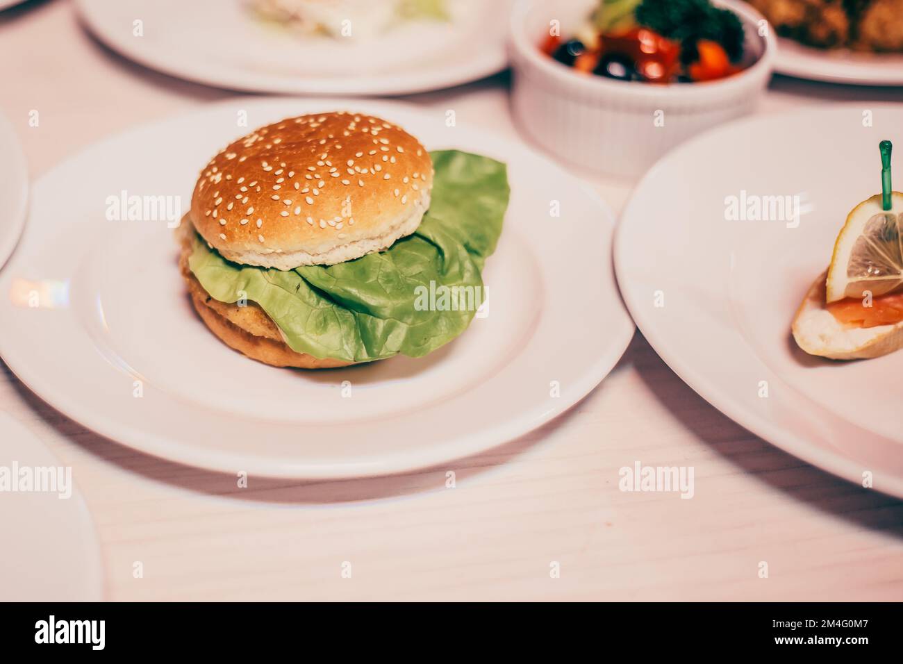 hamburger and other dishes on the table in the restaurant Stock Photo ...