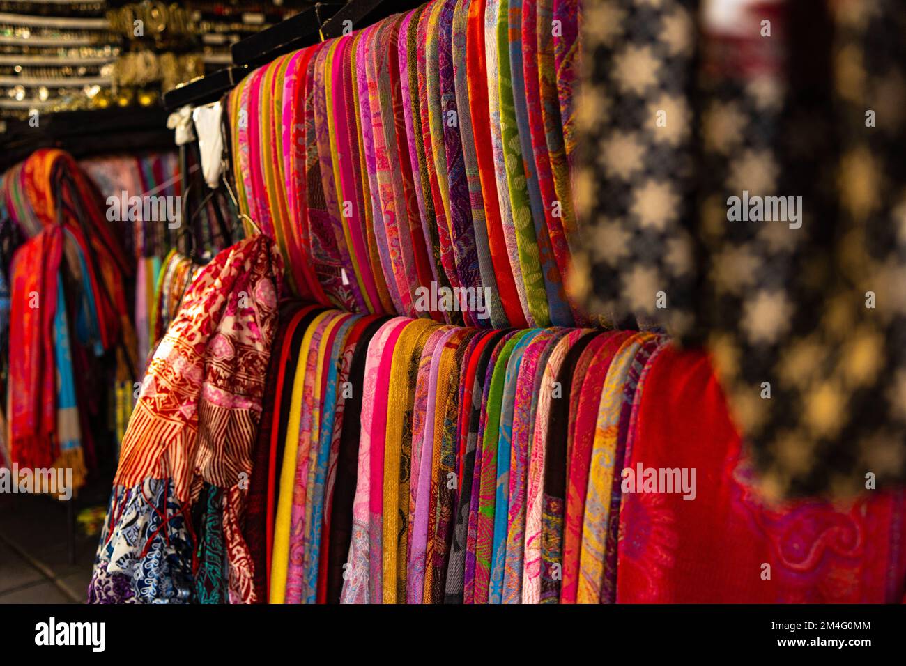A close-up collection of vibrant, colourful scarves at the local market ...