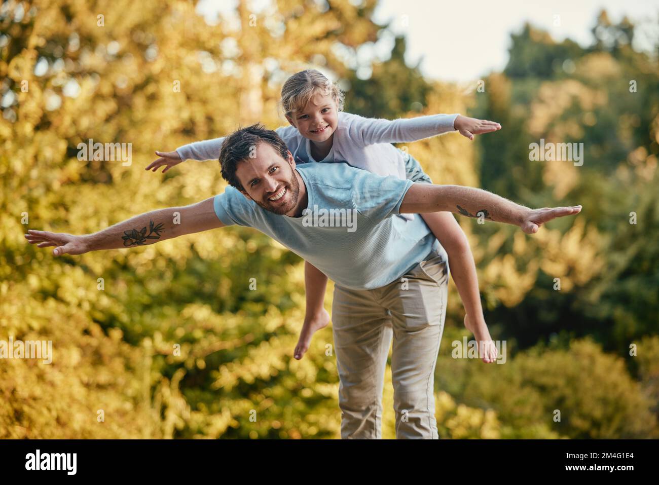Park, family and girl on back of father enjoying freedom on weekend ...
