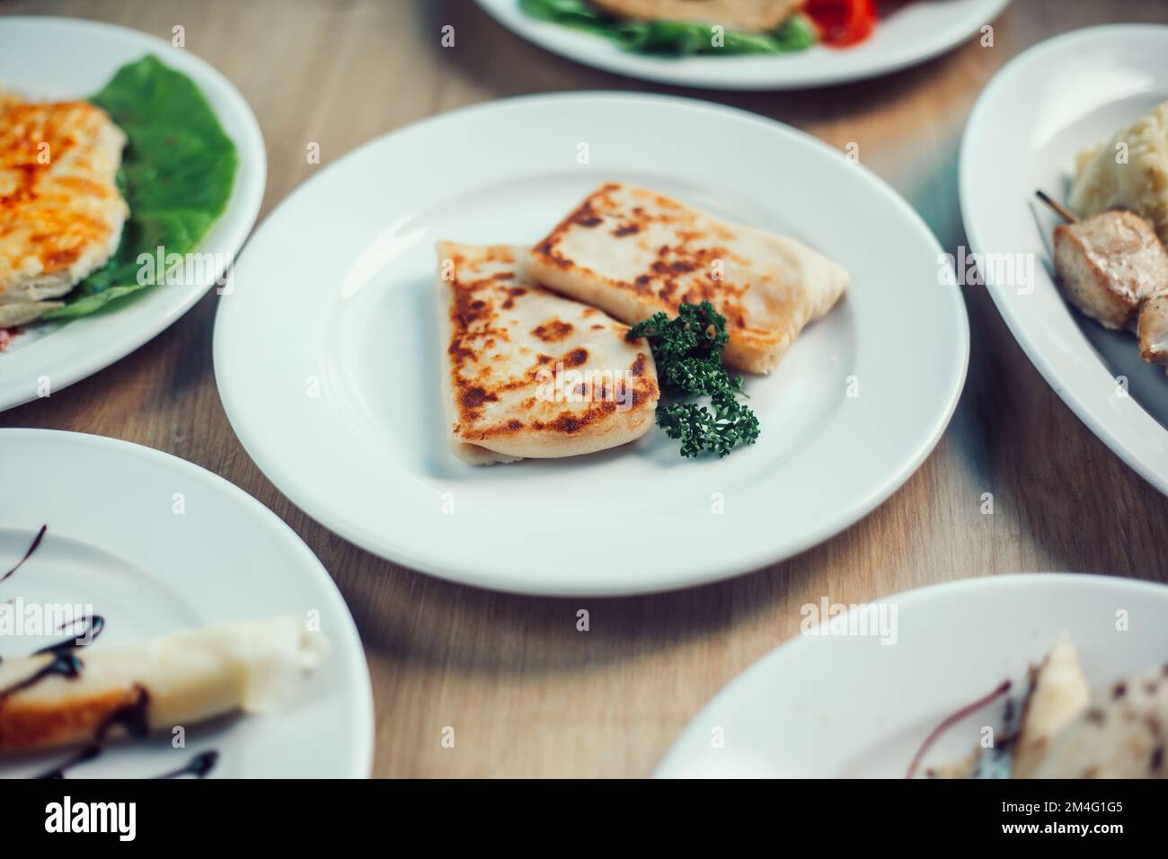 thin blinchiki with ham and other dishes on the restaurant table Stock ...