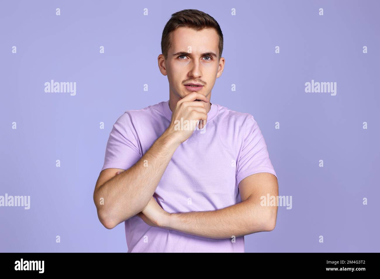 thoughtful man holding arms folded, touching chin with hand Stock Photo ...