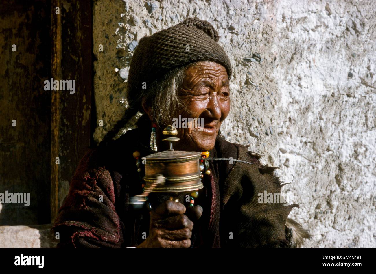 Old ladakhi lady turning her praying mill Stock Photo - Alamy