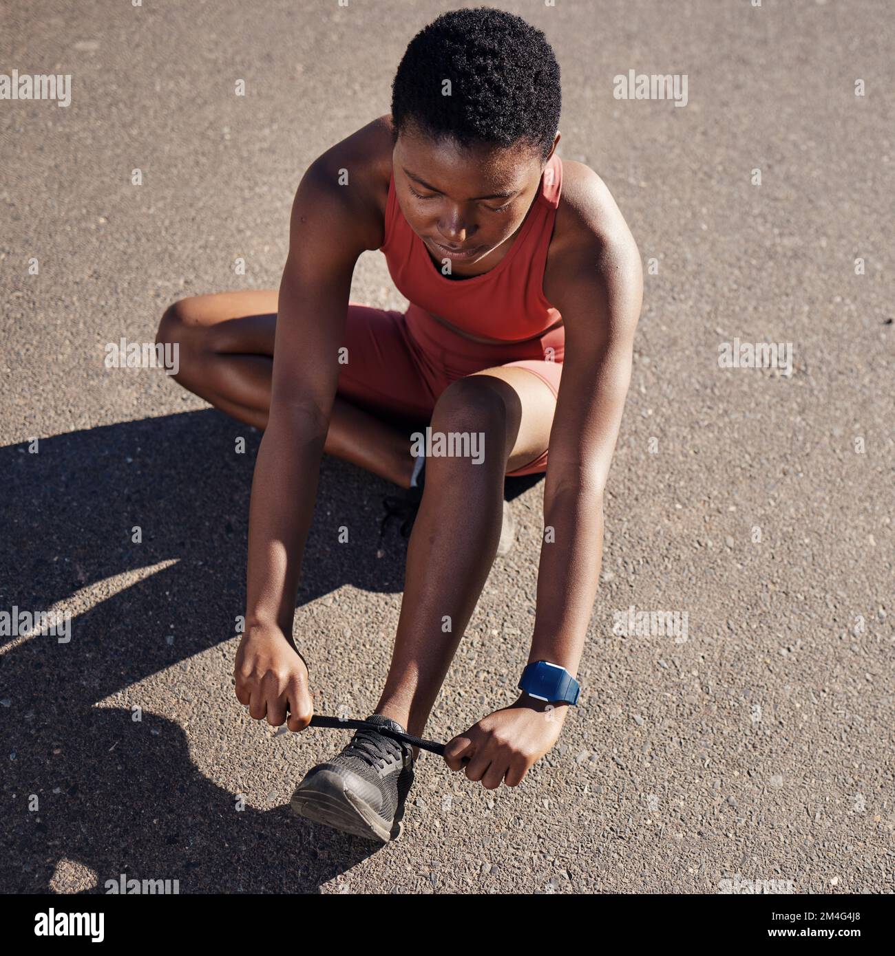 Running, fitness and tie shoes with black woman in road for cardio, workout and training. Sports ...