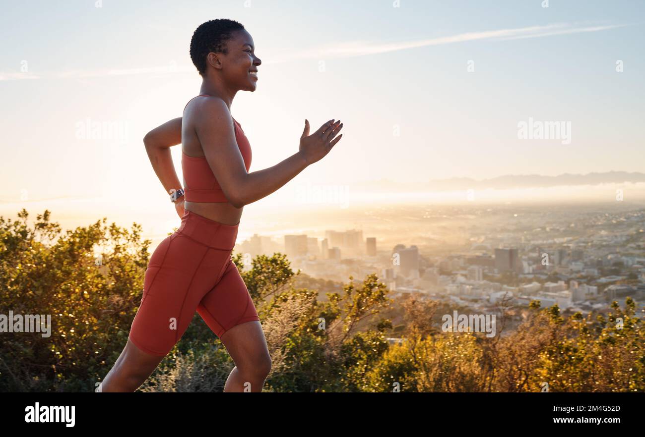 Running, black woman and fitness on sunset mountains, city background ...