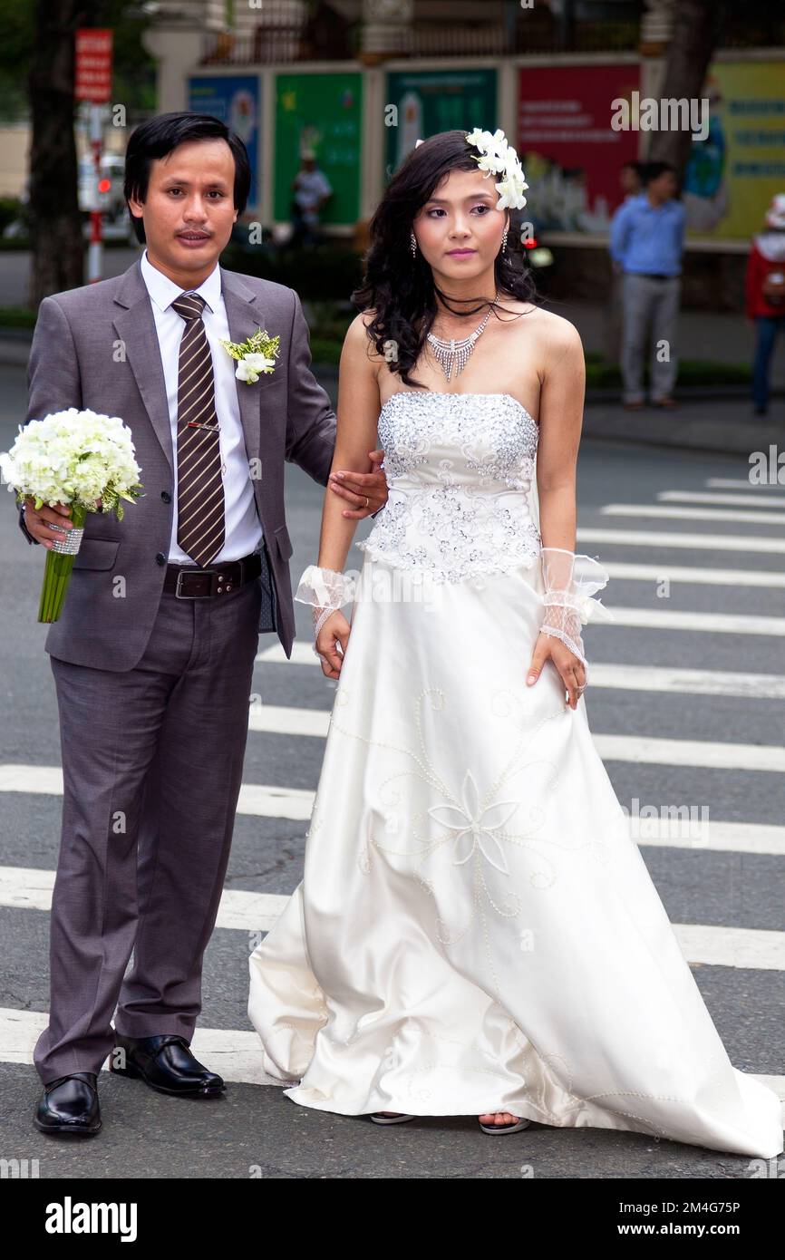 Vietnamese couple with bouquet posing for wedding photo crossing street ...
