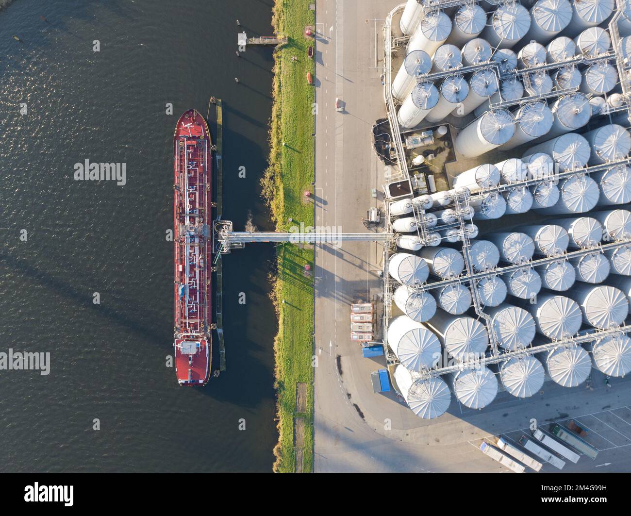 Petrochemical loading of ship at loading dock with pipelines and ...
