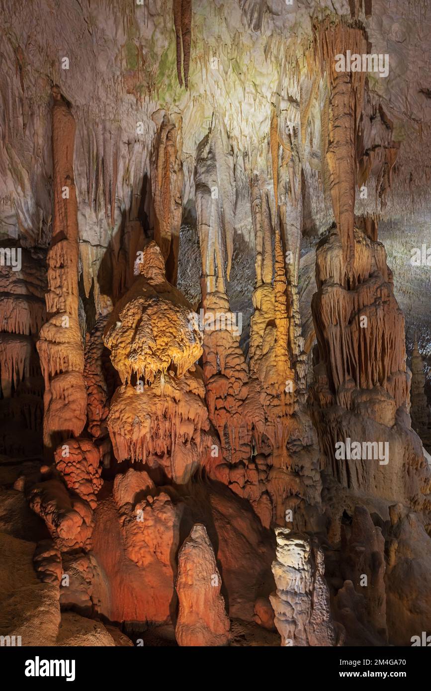 Intense red and orange columns in the Postojna cave. The white spots is ...