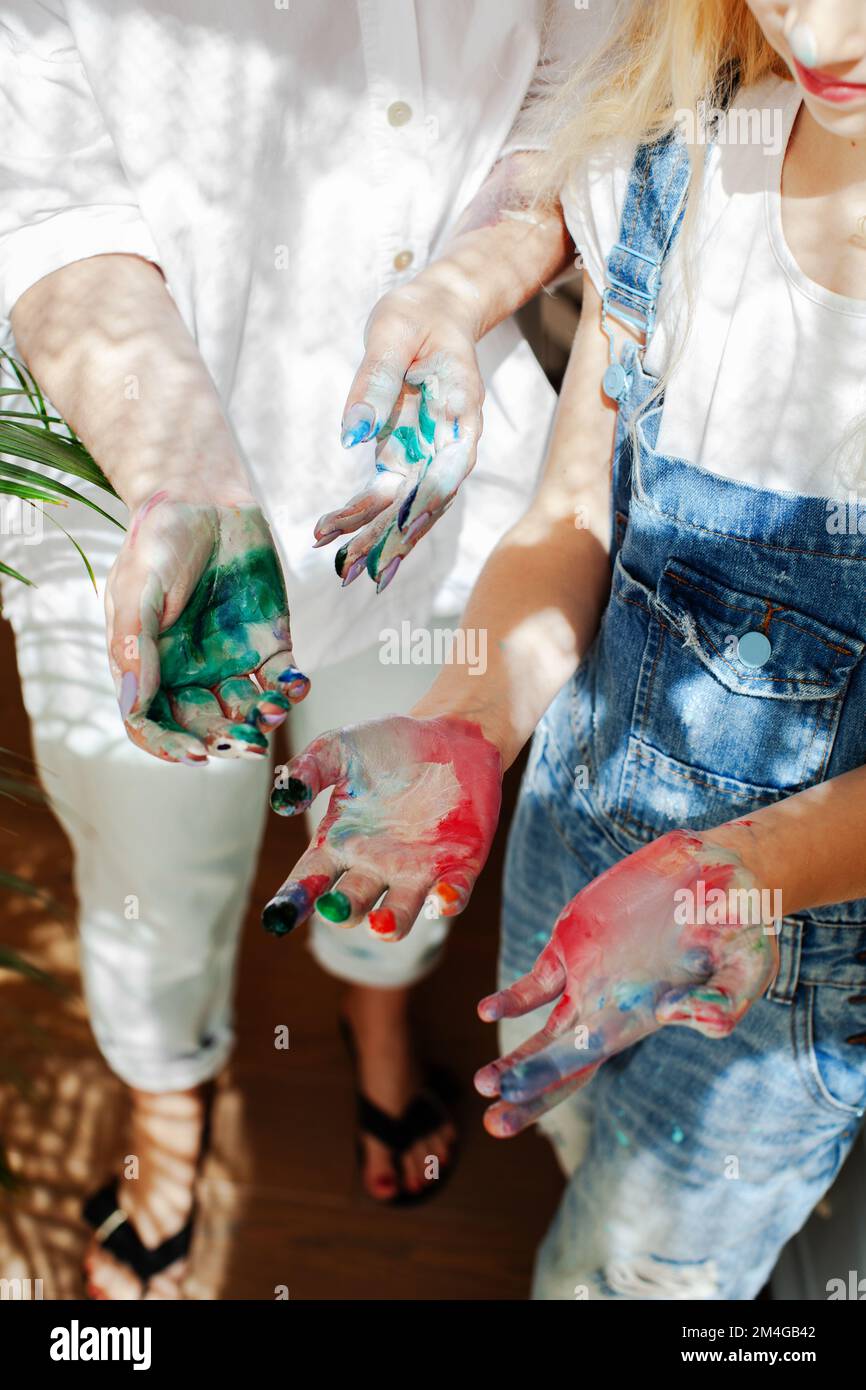 Close up of dirty stained painted hands with colourful paints after ...