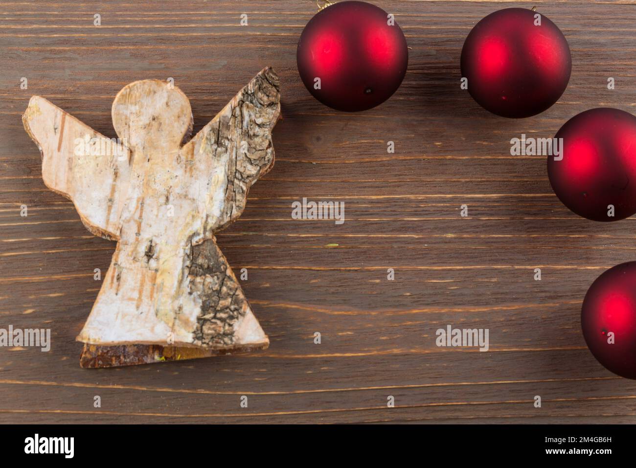 Christmas angle made of wood with red Christmas balls Stock Photo - Alamy