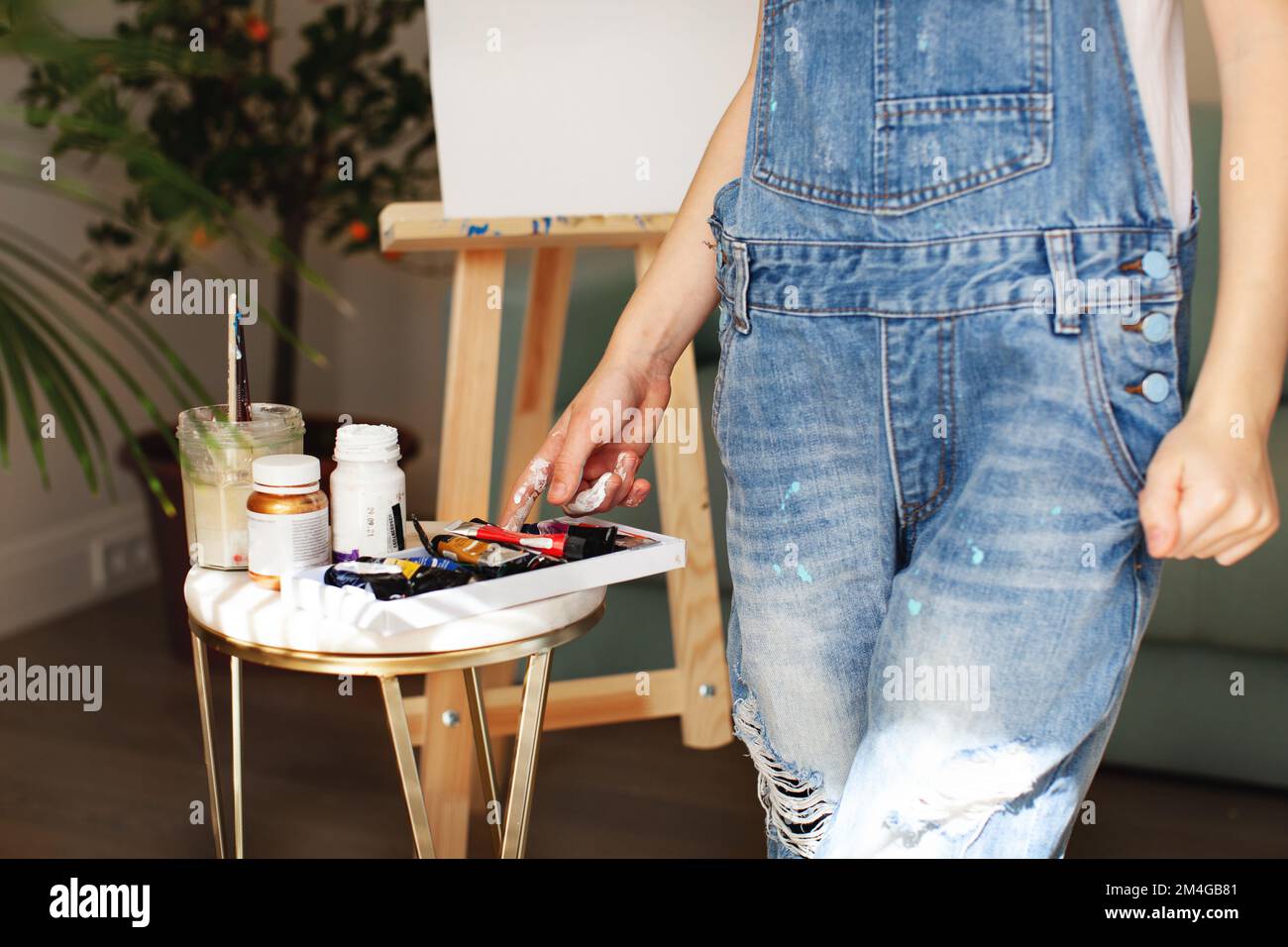 Child young artist touching tube of acrylic paint with stained colored ...