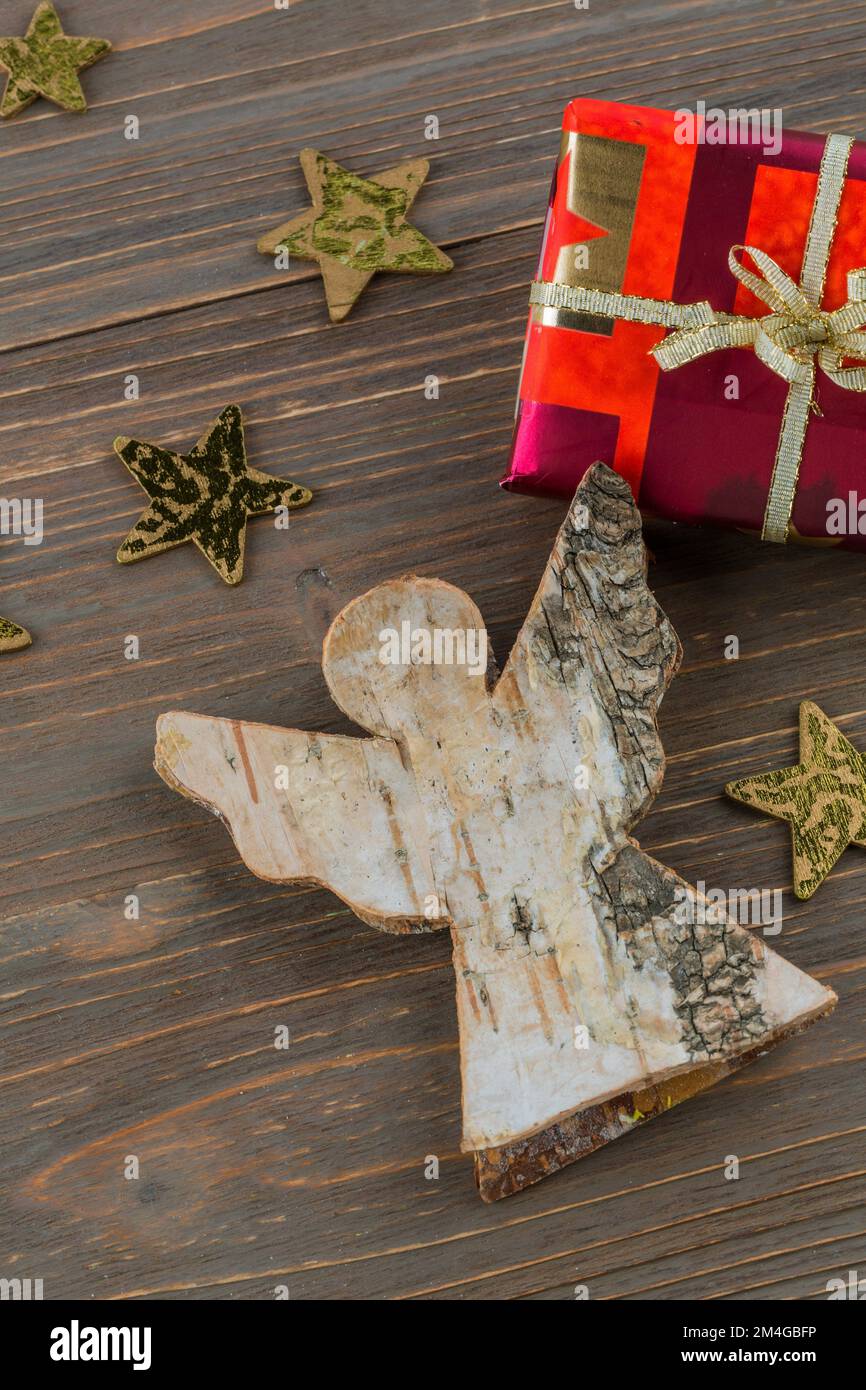 Christmas angle made of wood with yellow stars and gift Stock Photo - Alamy