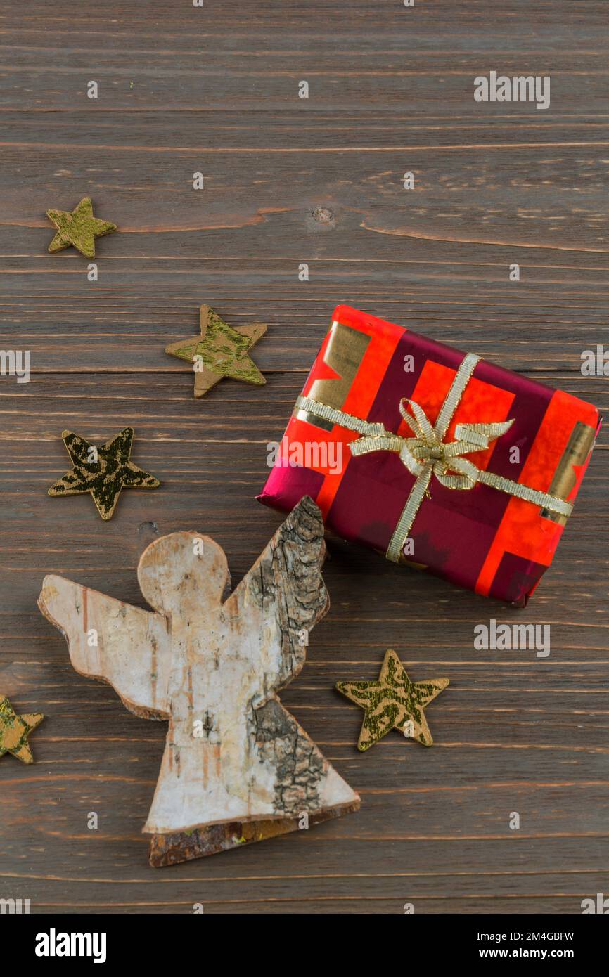 Christmas angle made of wood with yellow stars and gift Stock Photo - Alamy