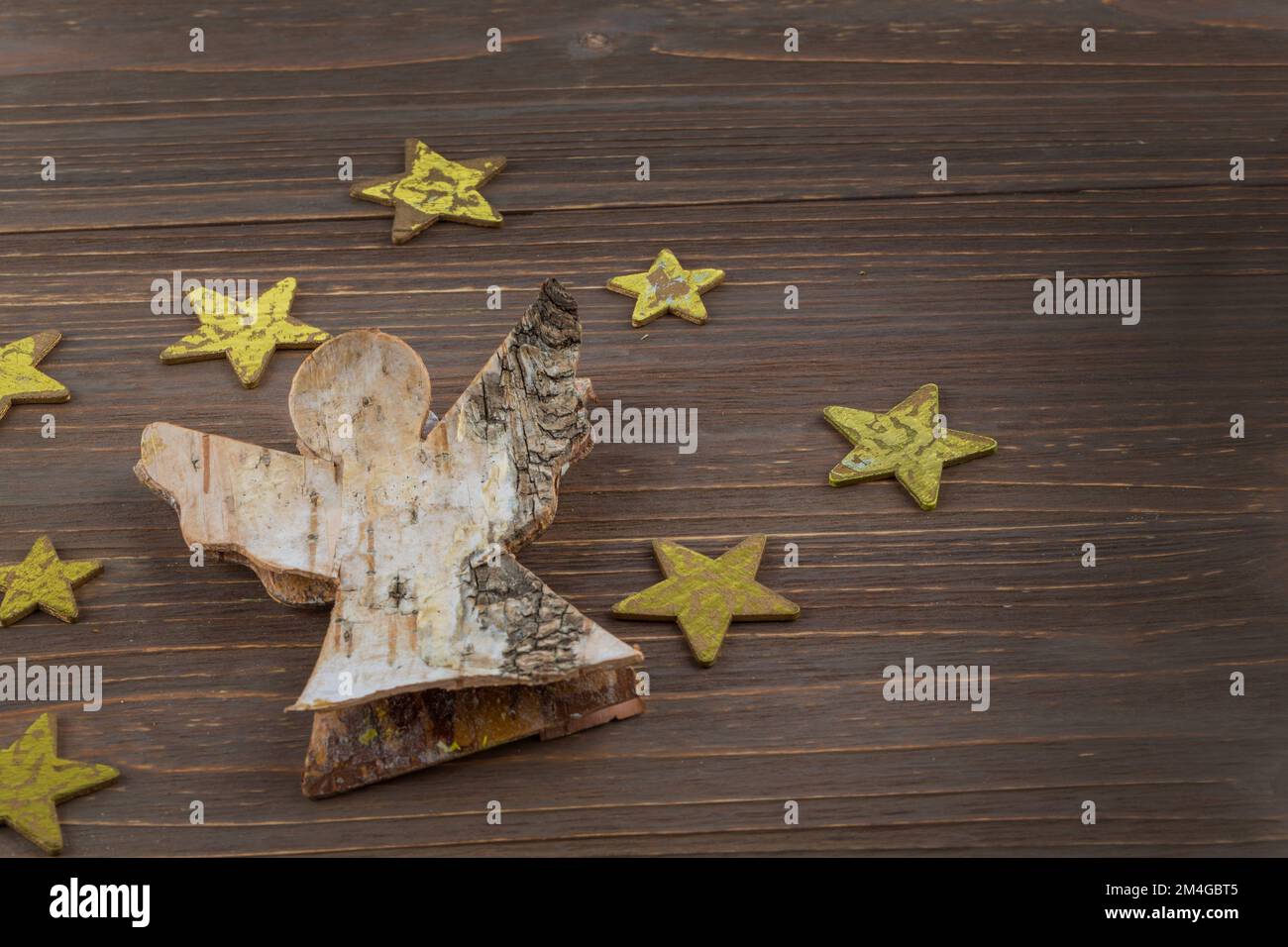 Christmas angle made of wood with yellow stars Stock Photo - Alamy