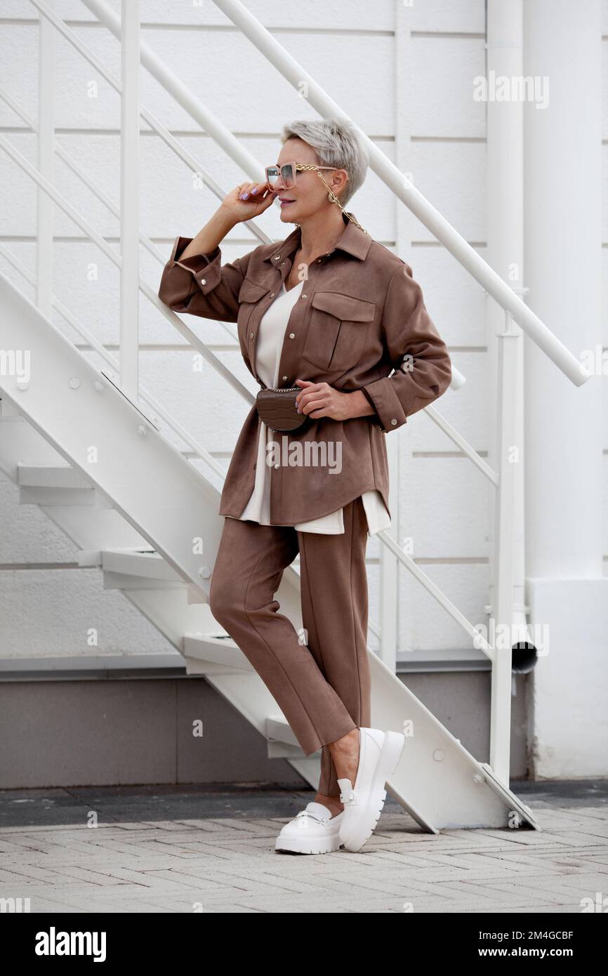 Fashionable woman stands. Short hair Model wears beige business suit ...