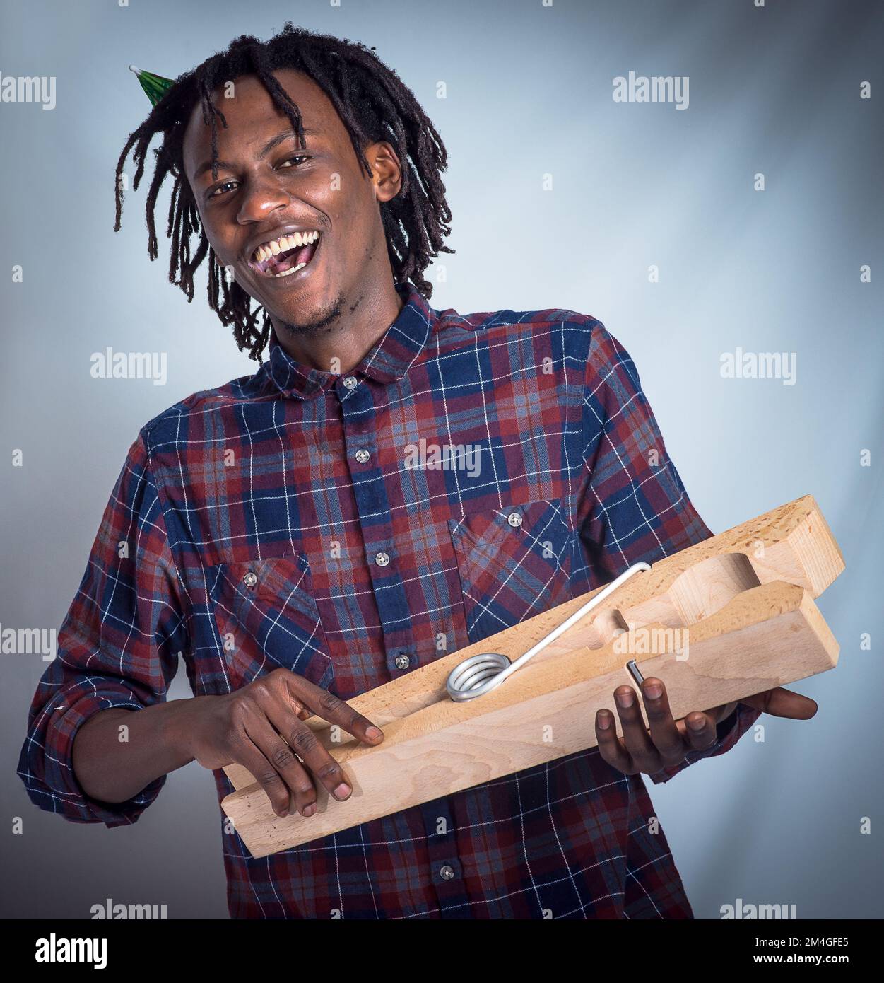 Portrait, prop and happy man holding giant peg looking cheerful on a ...
