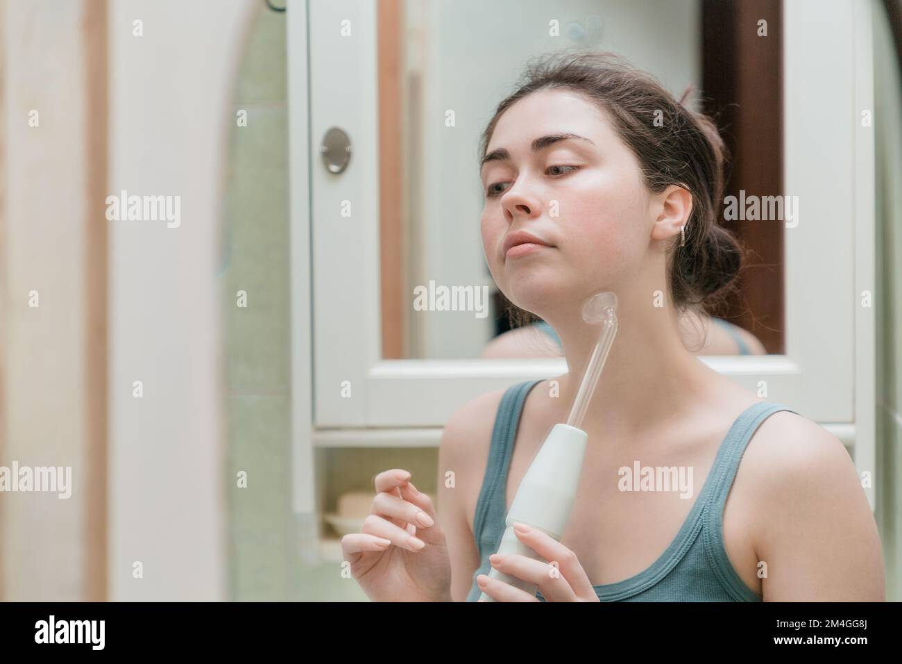 a young girl takes care of the skin of the face making procedures using ...