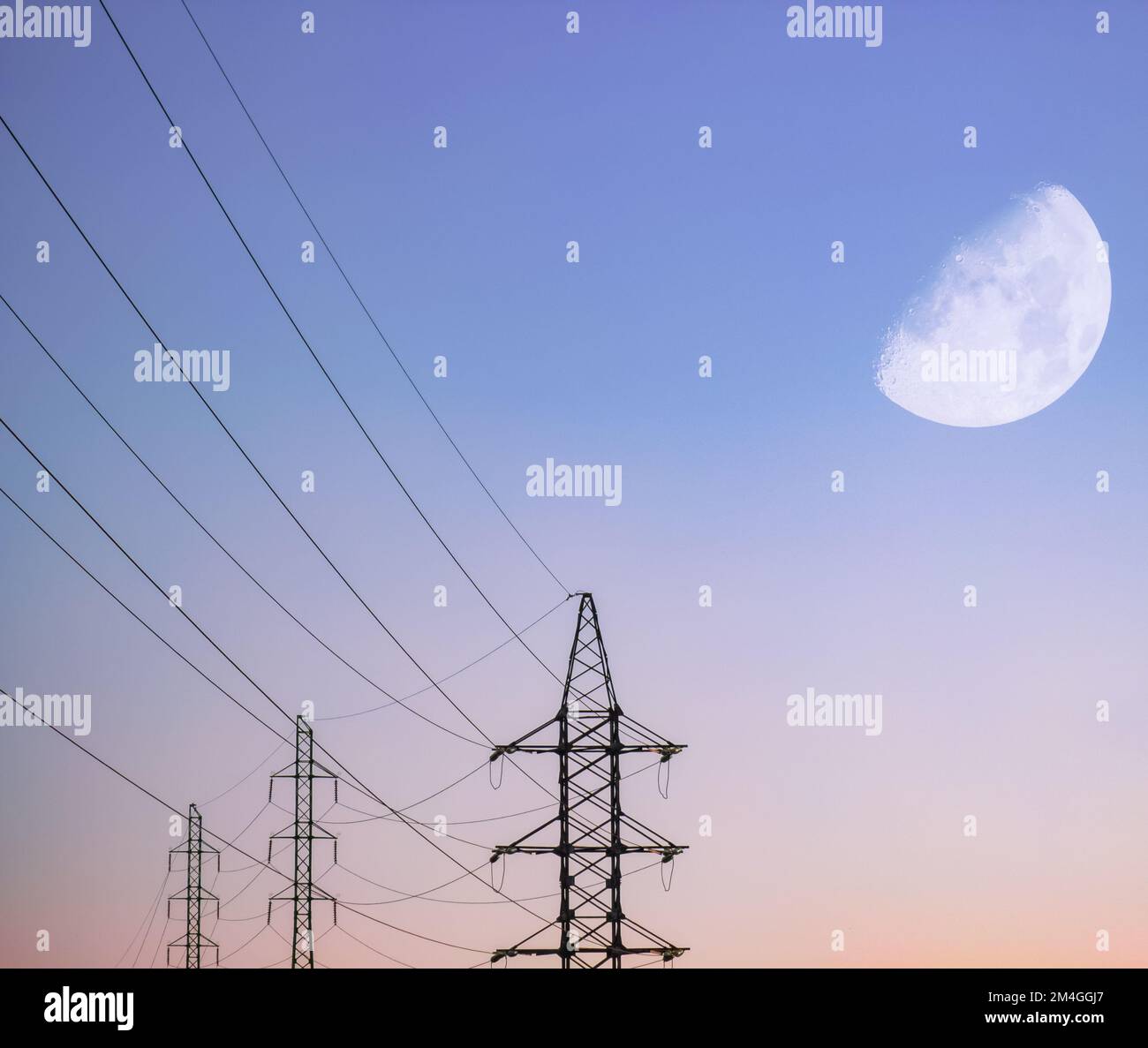 High voltage electricity power line towers. Huge moon in sky Stock ...
