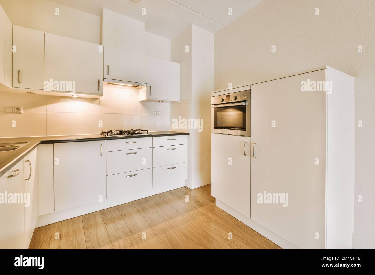 a kitchen with white cupboards and appliances on the counter top, in an ...