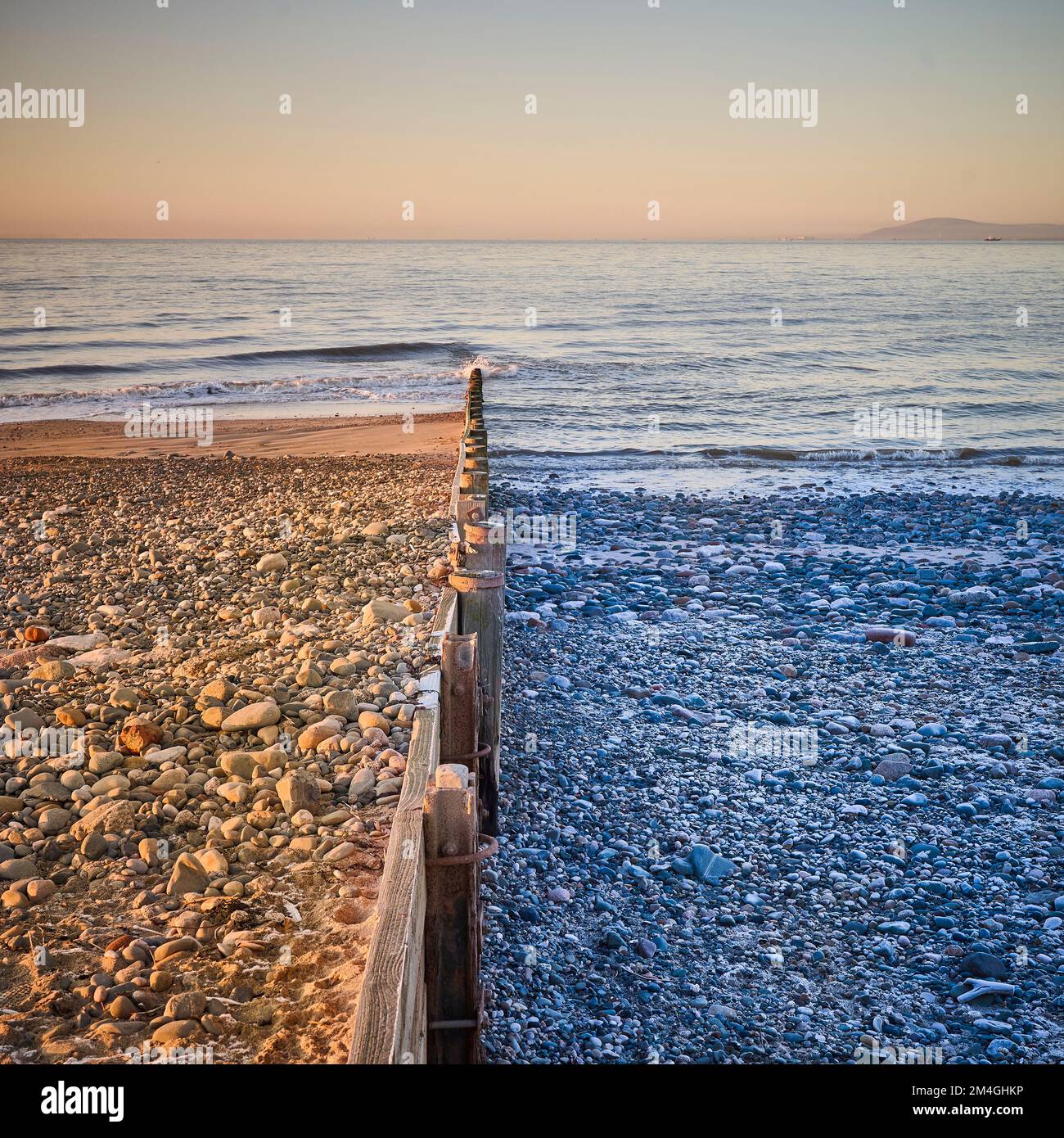 Pebble beach in shade and sunshine Stock Photo - Alamy
