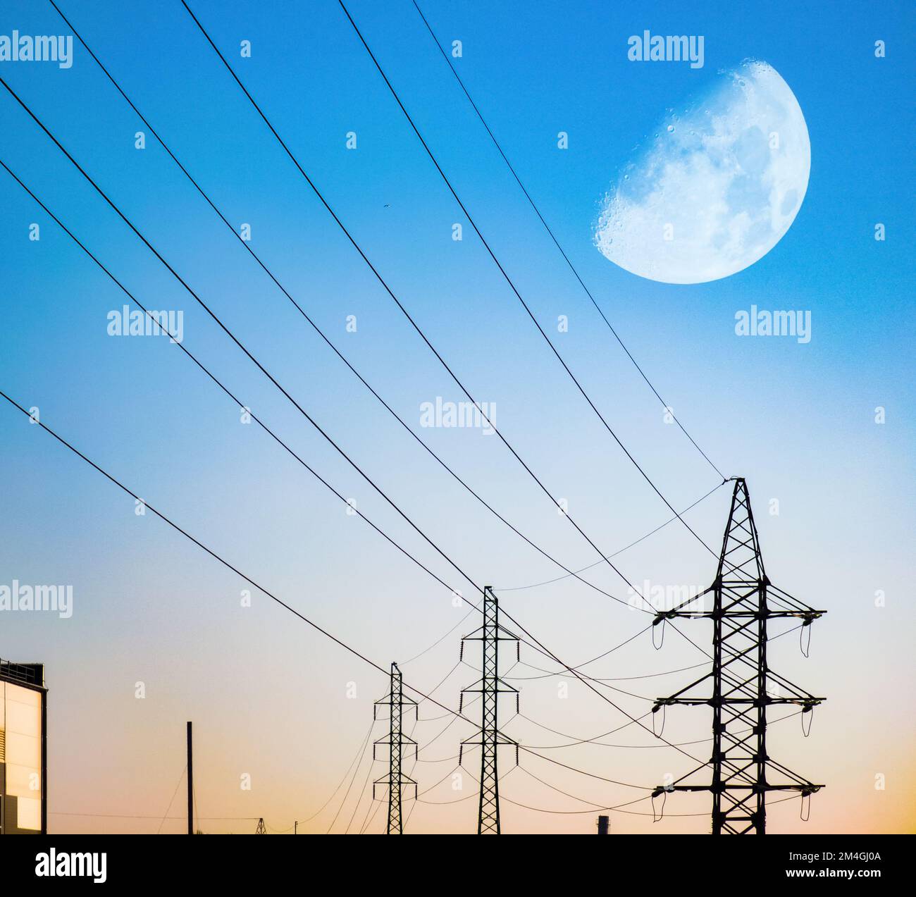 High voltage electricity power line towers. Huge moon in sky Stock ...