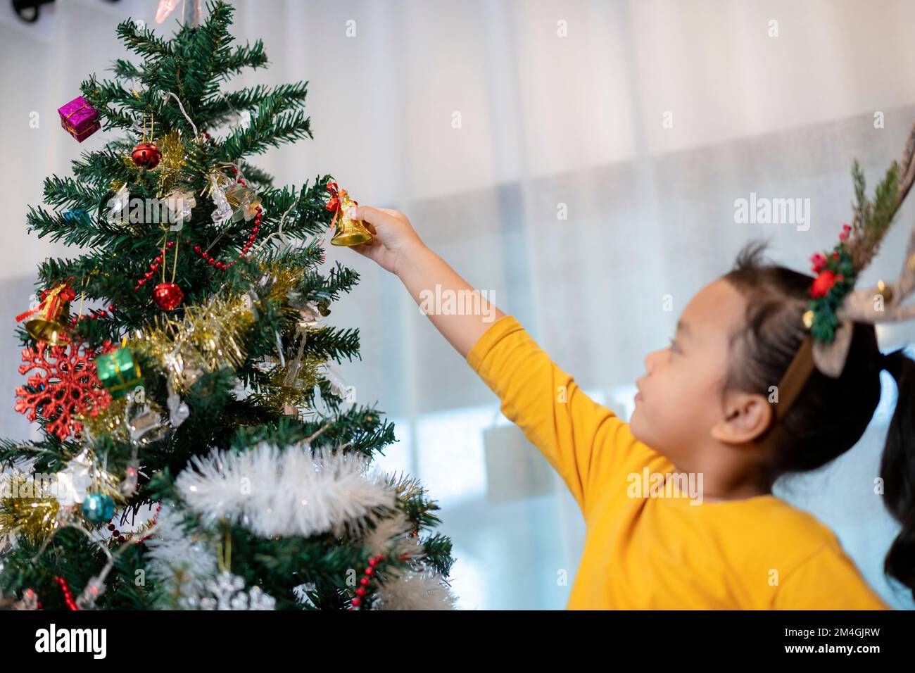 Happy Asian Baby girl decorate A Christmas tree at home, Happy New Year ...