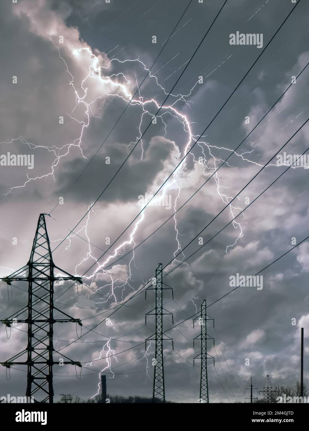 High voltage electricity power line towers against thunderstorm sky ...