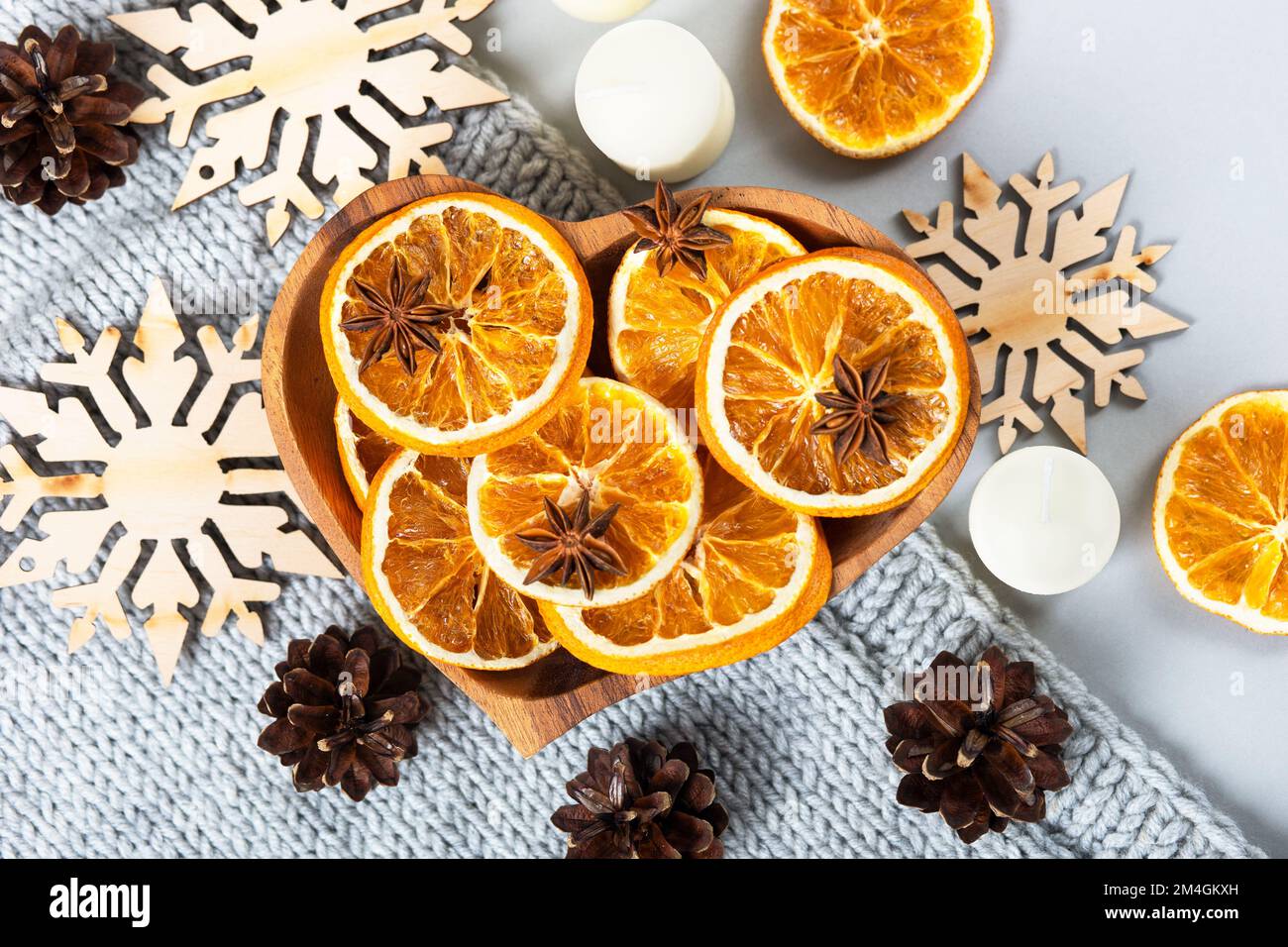 Winter cozy composition of knitted sweaters, dried oranges in a wooden ...