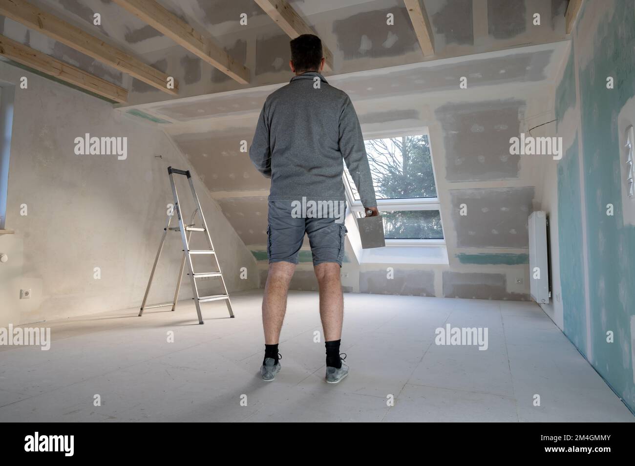 Man plastering drywall in a private house Stock Photo - Alamy